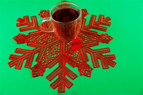 크로마키의 녹색의 밝은 배경에는 빨간색 투각 눈송이 투명한 차 한 잔이 있는 냅킨 텍스트를 위한 공간이 있는 새해 복 많이 받으세요 레이블이 있습니다 0명에 대한 스톡 사진