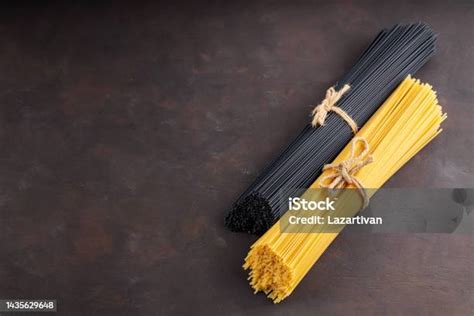 어두운 배경에 검은 색과 노란색 파스타 스파게티를 건조시킵니다 꼬기로 묶인 생 스파게티의 무리 평면도 복사 공간 건조한에 대한 스톡 사진 및 기타 이미지 Istock