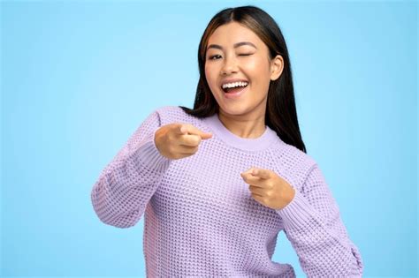 Premium Photo Portrait Of Joyful Woman Winking Playfully And Pointing To Camera Choosing Guy