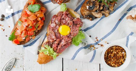 얇게 썬 빵에 소고기와 야채를 얹고 찍어 찍어 찍은 사진을 찍습니다 사진 Unsplash의 무료 음식 이미지