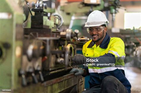 공장 생산 및 건설 작업 기술의 사업 제조 공장에서 산업 설비의 기계 설비를 사용하기 위해 안전 헬멧 안전모를 착용하는 전문 엔지니어 공장 산업 건물에 대한 스톡 사진 및