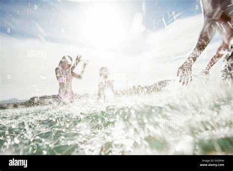 Vater Mit Sohn Und Tochter Spritzt Einander Am Strand Stockfotografie