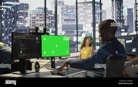 Developer With Disability Sitting In Wheelchair Fixing Applications Issues On Green Screen Pc