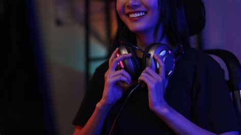 재미와 모니터에 비디오 게임을보고 목 주위 헤드폰 여성 사이버 해커 게이머 프리미엄 사진