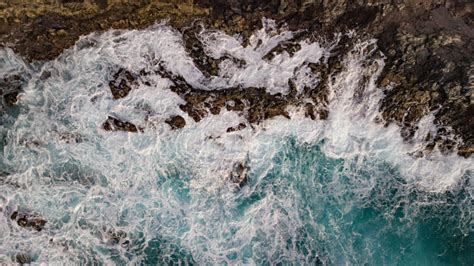 바위 절벽의 벽에 부딪히는 강한 너울이 있는 대서양 바위에 거품이 부딪히는 큰 파도가 있는 푸른 거친 바다 카나리아 섬 테네리페