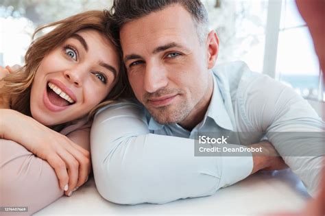 두 사랑스러운 젊은 남자와 여자 함께 재미 그리고 레스토랑에서 점심 시간을 하는 동안 아름 다운 셀카를 만들기 2명에 대한 스톡