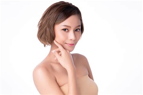 깨끗 하고 신선한 피부와 함께 부드러운 뺨과 미소를 만지는 아름 다운 젊은 아시아 여자 행복과 쾌활한 흰색 배경에 고립 아름다움과 화장품 개념 건강관리와 의술에 대한 스톡