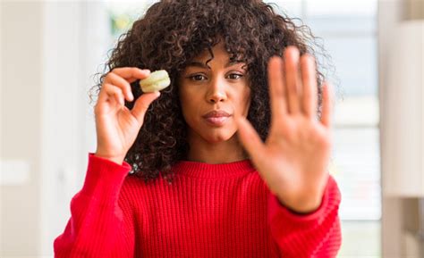 아프리카계 미국인 여 자가 심각 하 고 자신감 표현 방어 제스처 정지 표시를 하 고 오픈 손으로 마카롱을 들고 먹기에 대한 스톡 사진 및 기타 이미지 Istock