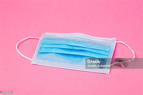 분홍색 배경에 보호 얼굴 마스크입니다 입과 코를 덮는 전형적인 3ply 수술 마스크 박테리아에서 절차 마스크 보호 개념입니다