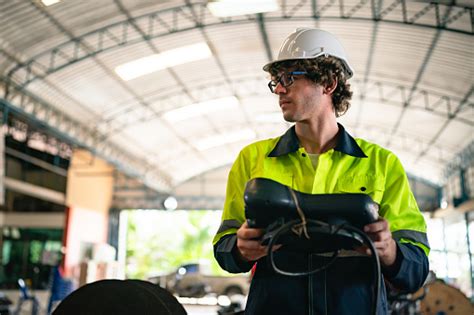 산업 공장에서 자동 로봇 기계를 점검 및 수리하는 로봇 컨트롤러를 들고 있는 전문 엔지니어 제조 생산을 위해 로봇 팔 시스템으로 작업하는 기술자 25 29세에 대한 스톡