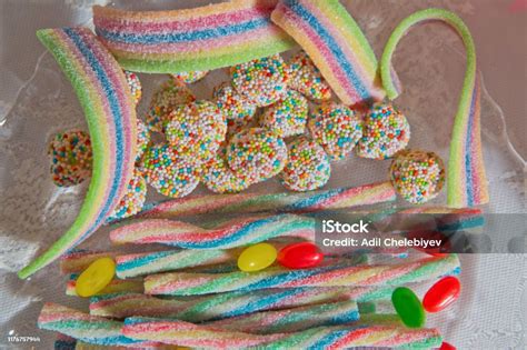 흰색 배경에 다채로운 거미 사탕 패턴 유니콘 무지개 사탕 줄무늬 배경 클로즈업 설탕 뿌리 둥근 색깔의 사탕 설탕 뿌리 신 무지개 과자 스트립 공휴일에 대한 스톡 사진 및