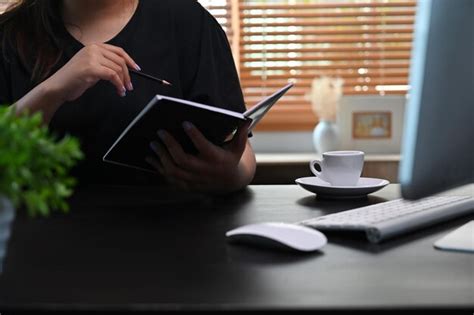 Premium Photo Female Using Computer And Making Notes On Notebook