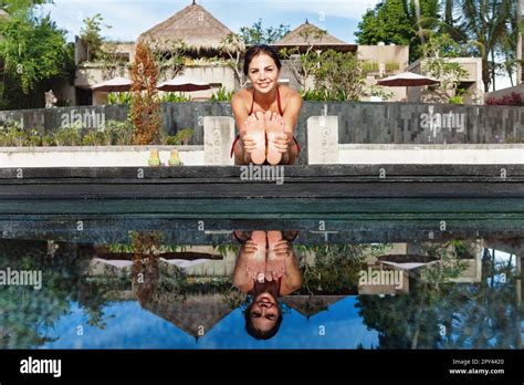 Active Woman In Bikini Practicing Yoga Stretching At Villa Poolside To