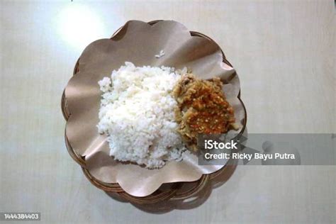 아얌 게프렉 인기있는 인도네시아 사람들 요리 라임 잎 칠리 소스를 곁들인 으깬 프라이드 치킨과 쌀 종이로 덮인 등나무 접시에 밥
