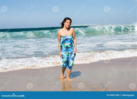 Женщина на пляже с большими волнами в предпосылке Стоковое Фото изображение насчитывающей небо