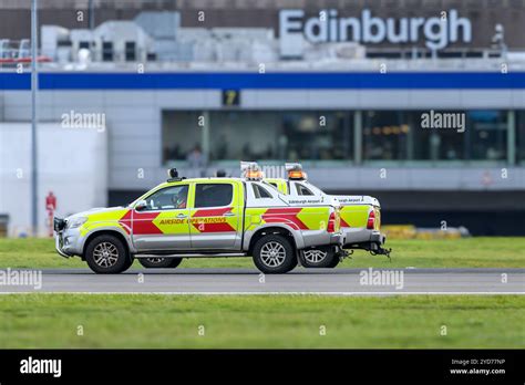 Two Edinburgh Airport Airside Operations Vehicles Perform A Runway Inspection For Foreign Object