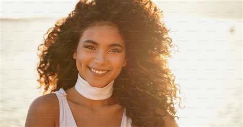 아프리카 헤어스타일을 가진 행복하고 아름다운 콜롬비아 여성의 아름다움 초상화를 닫습니다 카메라를 보고 웃고 있는 소녀 일몰 빛 사진 Unsplash의 머리 이미지