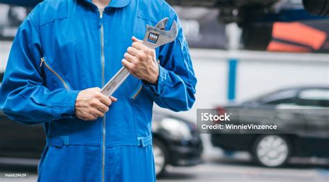 자동차 수리 차고에 있는 렌치 장비 도구를 잡고 있는 정비공 고장난 자동차 손상 확인 차량 수리 사업 서비스 후 모터 기술자 유지 보수 복사 공간 고용과 노동에 대한 스톡