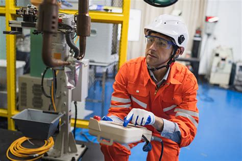 백인 기술자 엔지니어 남자는 공장에서 기계 팔 로봇을 확인하는 원격 제어를 사용합니다 전기 연료 및 전력 생산에 대한 스톡 사진 및 기타 이미지 전기 연료 및 전력 생산