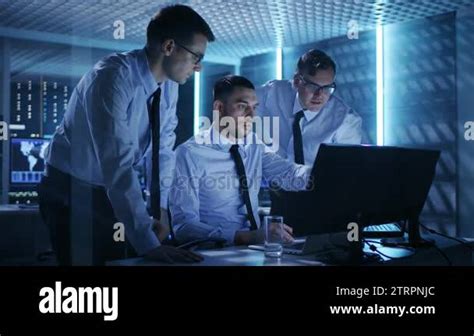 three operations engineers solving problem in a monitoring room in
