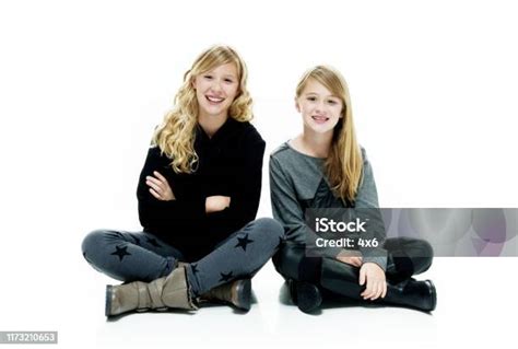 2 명 전체 길이 전면 보기 89 년 1011 세 아름 다운 금발 머리 긴 머리 백인 세대 Z 젊은 여자 여자 십 대 여자 우정 바닥에 앉아 흰색 배경 앞에 앉아 카메라를