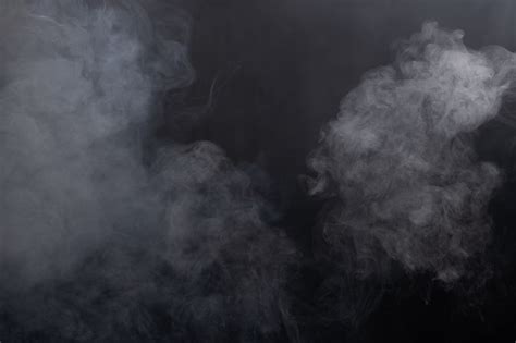 검은 배경에 흰 연기와 안개가 짙은 푹신한 퍼프 추상적인 연기 구름 초점이 흐려진 움직임 공기 중에 펄럭이는 기계 드라이 아이스 파리에서 연기가 나고 효과 질감 개념에 대한