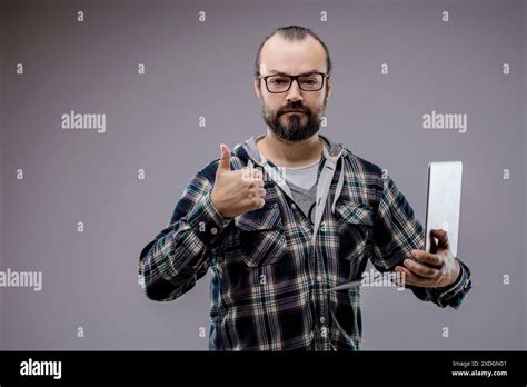 Confident Technician Holding Laptop Giving Thumbs Up For Successful Cyber Security Solution