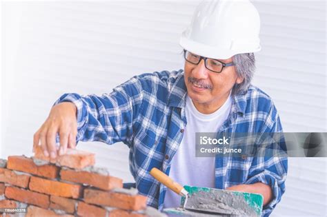 오래된 건설 노동자는 보호 빌더 하드 모자를 착용 시멘트 벽돌 벽을 누워있다 석공에 대한 스톡 사진 및 기타 이미지 석공 개발 건설 산업 Istock