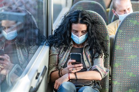 버스로 여행하는 동안 휴대 전화에 문자 메시지를 보내는 보호 얼굴 마스크를 가진 중간 성인 여성 스마트폰에 대한 스톡 사진 및 기타 이미지 Istock