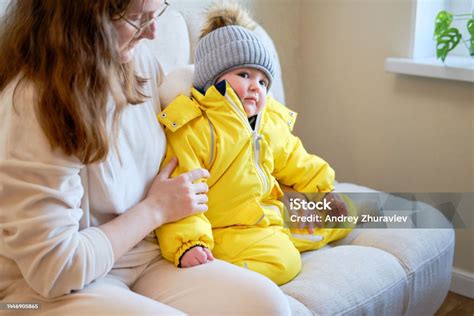 아이는 따뜻한 겨울 옷을 입고 밖에서 산책을 합니다 여자 어머니는 추운 날씨에 유아 아기에게 옷을 입힌다 아이 나이 1 년 5 개월 가정 거실에서 12 17 개월에 대한