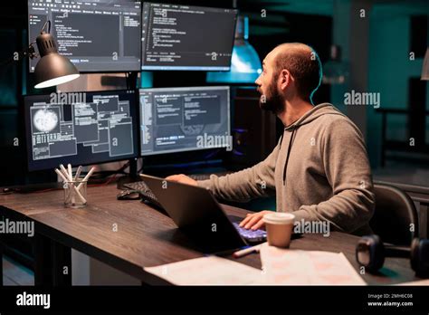 Software Developer Coding Database On Multiple Monitors To Program New Server Interface At Night