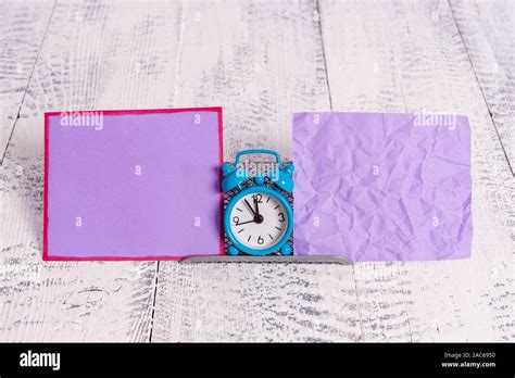 Mini Blue Alarm Clock Standing Above Buffer Wire Between Two Notation