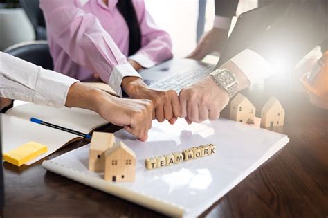 전문 사업가와 직원 팀은 책상 위에 팀워크라는 단어와 함께 나무 블록에 손을 얹습니다 나무 블록에 단어 팀워크 팀이 함께 손을 잡습니다 화합과 팀워크 개념 25 29세에