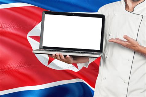 북한 국기 배경에 빈 화면으로 노트북을 들고 북한 요리사 복사 공간에 대 한 유니폼과 포인팅 노트북을 입고 요리 고급 요리에 대한 스톡 사진 및 기타 이미지 Istock