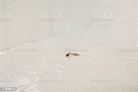 하얀 모래 해변에 물에 누워 휴가를 즐기는 여자의 공중 무인 항공기 샷 열대 여행 개념입니다 개념에 대한 스톡 사진 및 기타 이미지 Istock