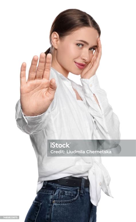 Embarrassed Young Woman Covering Face With Hand On White Background