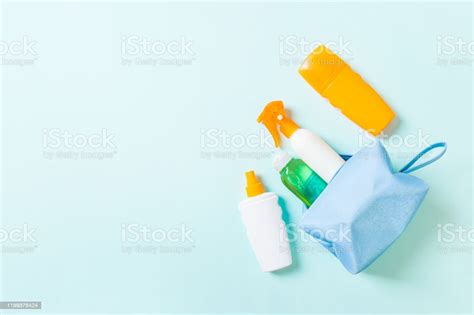 선크림 스프레이 선스린 선블록 바디 로션 Spf 크림이 가득한 여성 화장품 가방의 탑뷰를 복사 공간이 있는 파란색 배경에 있습니다 바로 위의 밝은 여름 컨셉 태양 하늘에