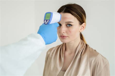 병원에서 환자의 체온을 측정하기 위해 적외선 온도계를 사용하는 의사 20 24세에 대한 스톡 사진 및 기타 이미지 20 24