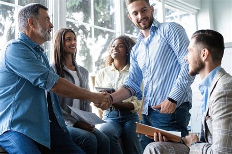 우리 팀에 오신 것을 환영합니다 창의적인 사무실에서 일하면서 악수를 하는 스마트 캐주얼 의상을 입은 비즈니스 맨 50 59세에 대한 스톡 사진 및 기타 이미지 Istock