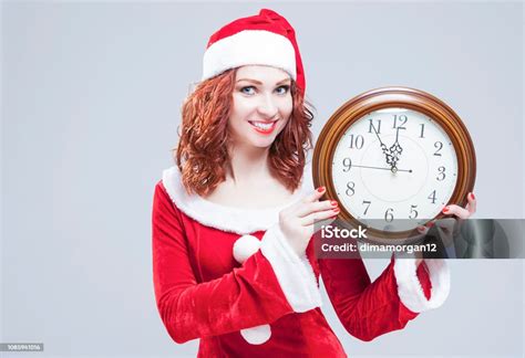 시간 하 고 크리스마스 휴가 개념입니다 미소의 초상화와 즐거운 빨간 머리 산타 헬퍼 큰 시계에 시간을 보여주는 흰색 배경에 대 한 수평 주사 12월에 대한 스톡 사진 및