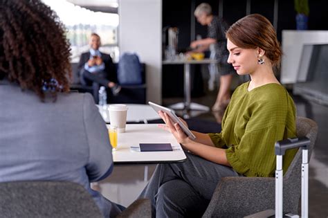 현대 공항 터미널에서 함께 비행을 기다리는 태블릿에서 일하는 다양한 사업가와 사업가 4 명에 대한 스톡 사진 및 기타 이미지