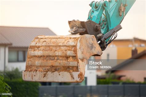 도로 수리 굴삭기는 쌓인 흙을 아스팔트가 없는 곳에 쏟아 붓습니다 집의 배경에 굴착기로 땅을 파는 과정 개발에 대한 스톡 사진 및 기타 이미지 Istock