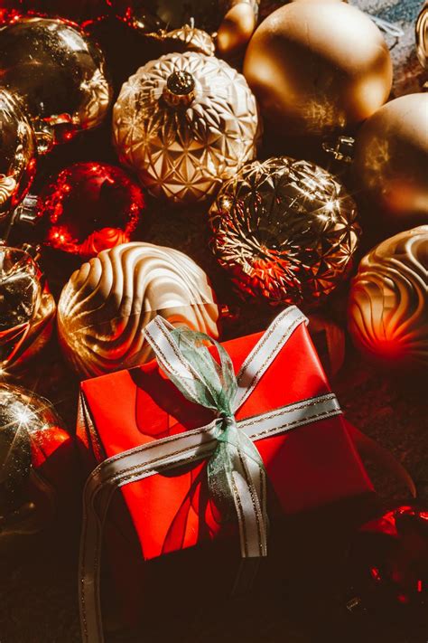 가벼운 겨울 겨울 축하 계절 구형 장식품 금 장식 리본 메탈릭 명절 선물 반짝이는 장신구 번쩍 거리는 보여주다 빛나는 빨간 리본 생생한 선물