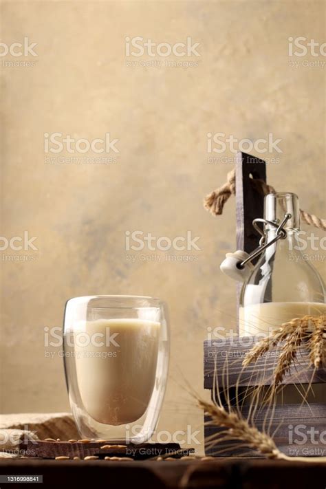 비건 유기농 아침 식사 음료 글루텐과 유당 무료 귀리 우유는 유리 병에 나무 배경에 상자에 유리 컨트리 스타일 건강 개념 공간을 복사합니다 수직 위치입니다 개념에 대한 스톡