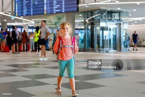 공항 터미널에 있는 어린 미취학 소녀 비행기로 휴가를 가는 행복한 아이 여권과 가방을 들고 웃는 아이 가방에 대한 스톡 사진 및