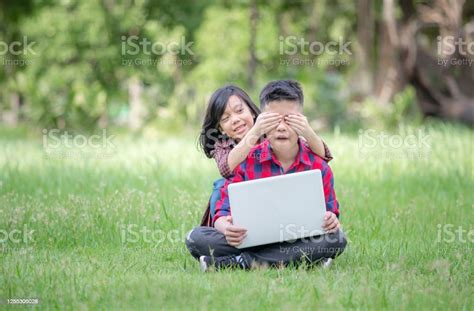 랩톱 명랑한 소년과 공원에서 소녀와 잔디에 앉아 형제 자매 아이들 재생 및 야외 학습 개념 2명에 대한 스톡 사진 및 기타 이미지 Istock