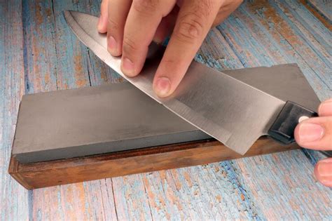 Premium Photo Hand Of A Man Sharpening A Knife