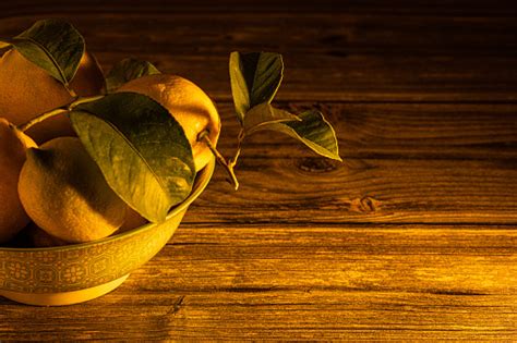 테이블 위에 녹색 잎과 검은 색 배경이있는 신선하고 유기농 레몬으로 가득 찬 그릇의 사이드 사진 일몰의 강렬한 측면 조명 건강한 생활방식에 대한 스톡 사진 및 기타 이미지