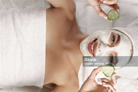 아름다운 젊은 여성은 눈에 오이와 누워 스파에서 얼굴 점토 마스크를 받고있다 스킨 케어 25 29세에 대한 스톡 사진 및 기타 이미지 Istock