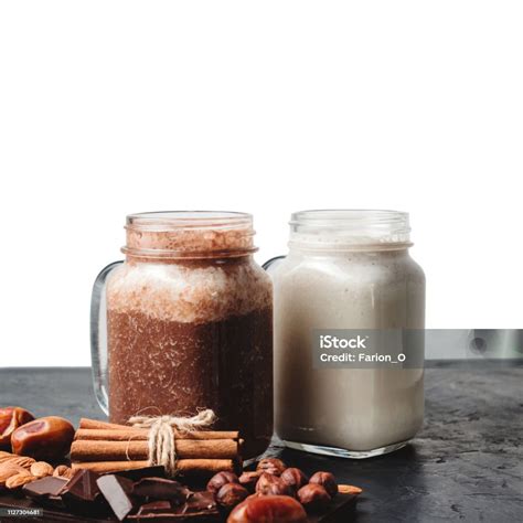 바나나와 초콜릿 스무디 2 단지 단백질 밀크 견과류 초콜릿 조각 날짜 계 피 스틱 흰색 배경에 절연 어둠 테이블 스무디에 대한 스톡 사진 및 기타 이미지 Istock
